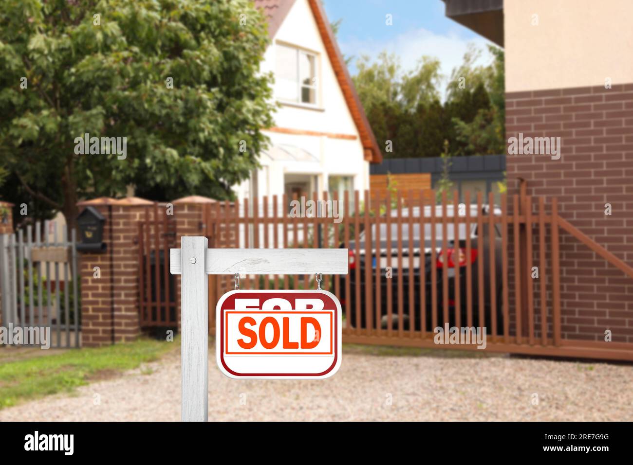 Red sale sign with Sold sticker near house Stock Photo - Alamy