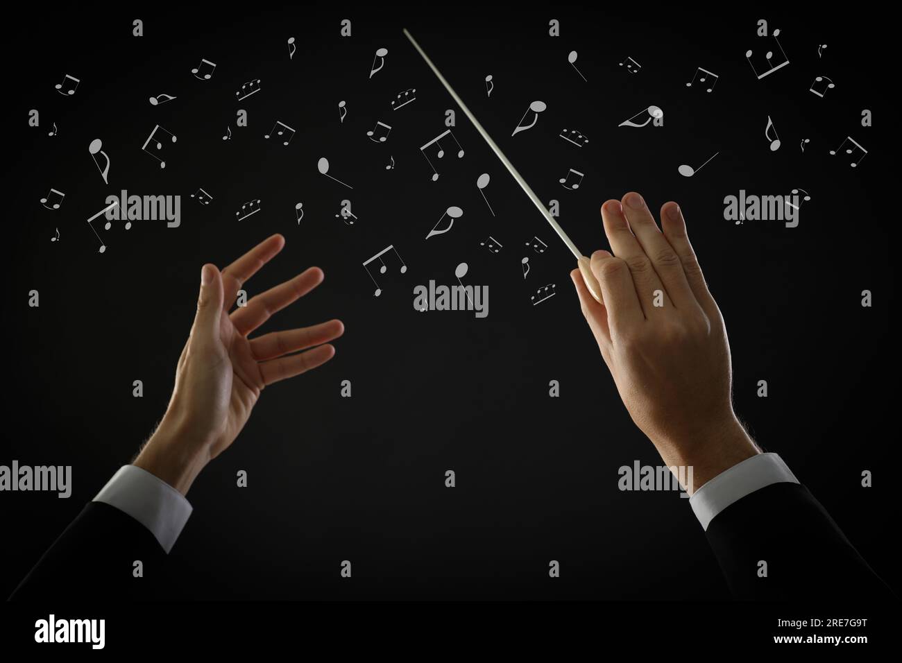 Conductor with baton and music notes on dark background, closeup Stock ...