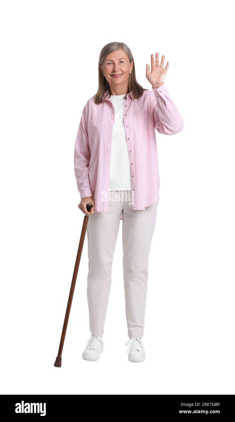 Senior woman with walking cane waving on white background Stock Photo ...