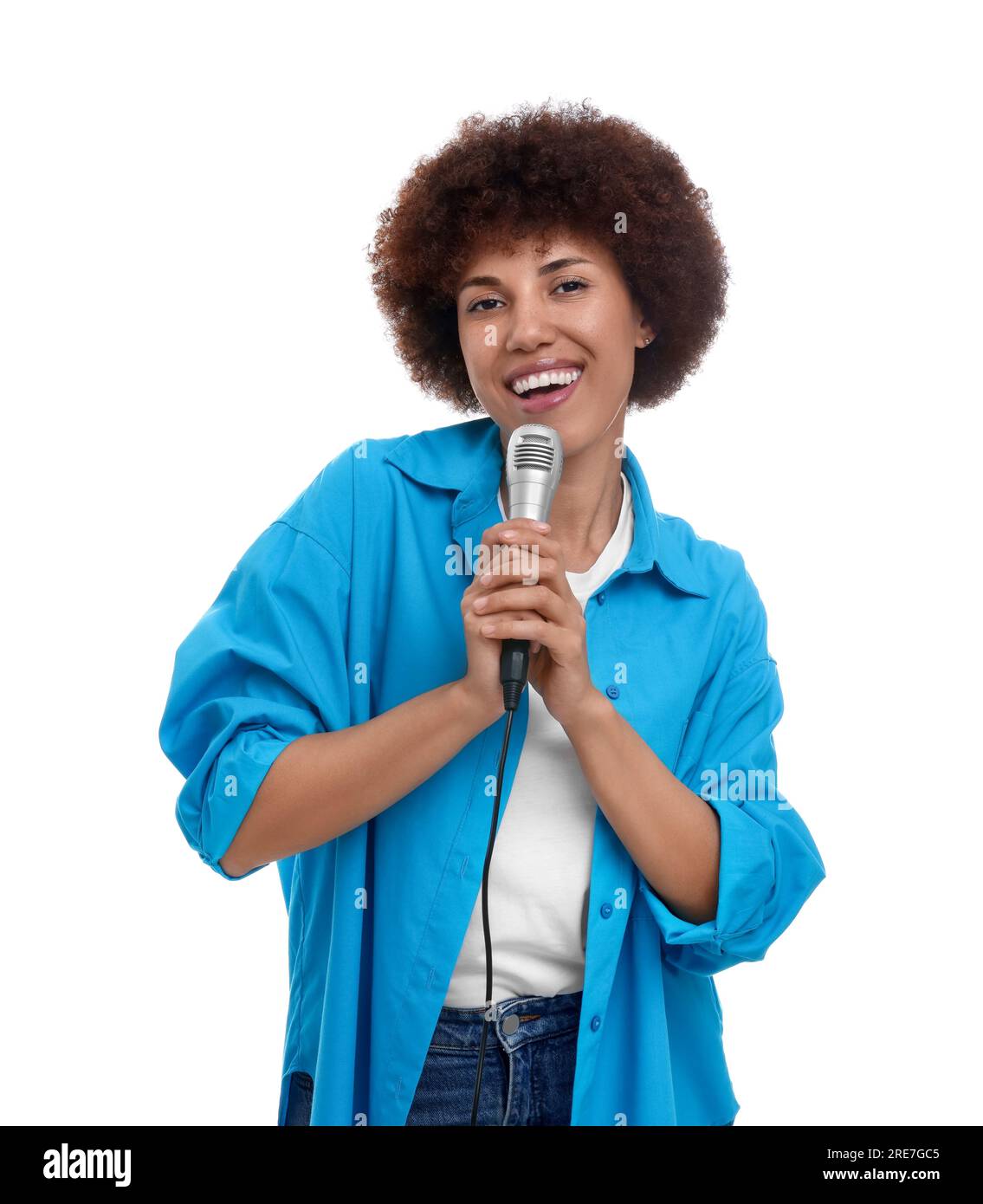Curly young woman with microphone singing on white background Stock ...