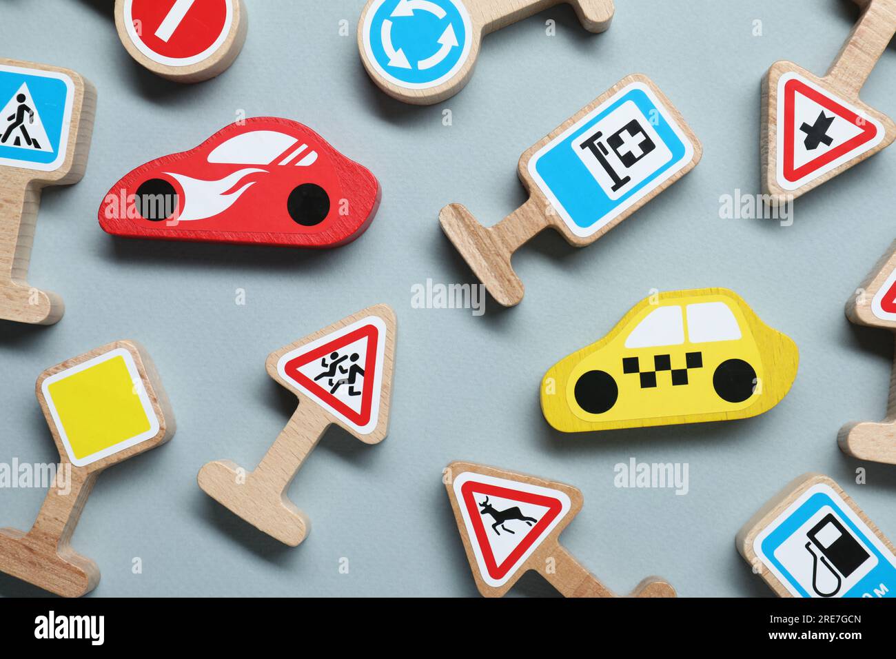 Set of wooden road signs and cars on light grey background, flat lay ...