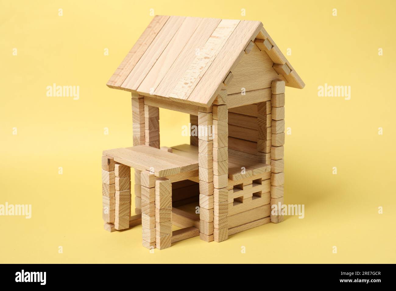 Wooden building on yellow background. Children's toy Stock Photo - Alamy