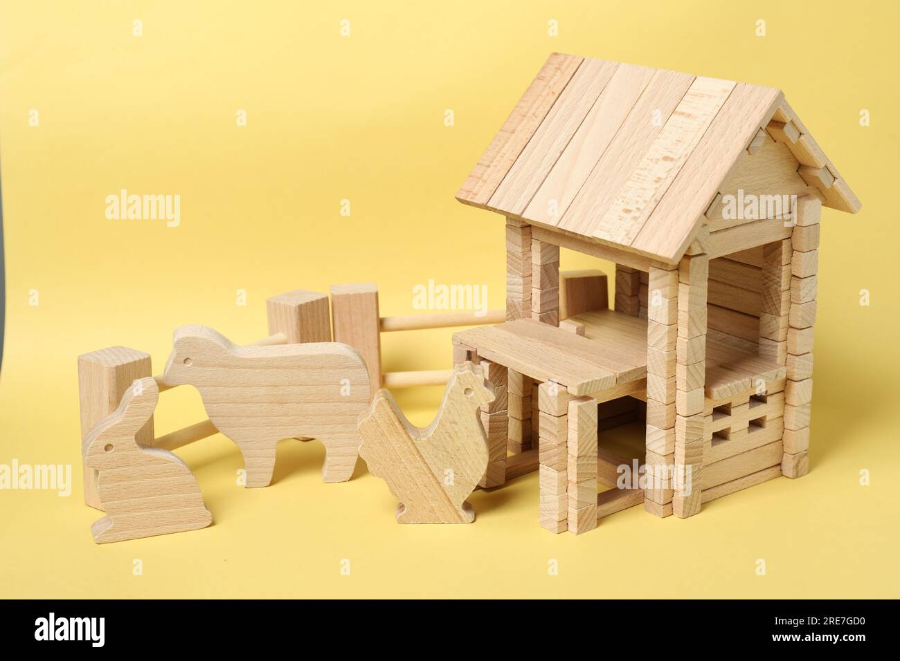 Wooden house and animals on yellow background. Children's toy Stock ...