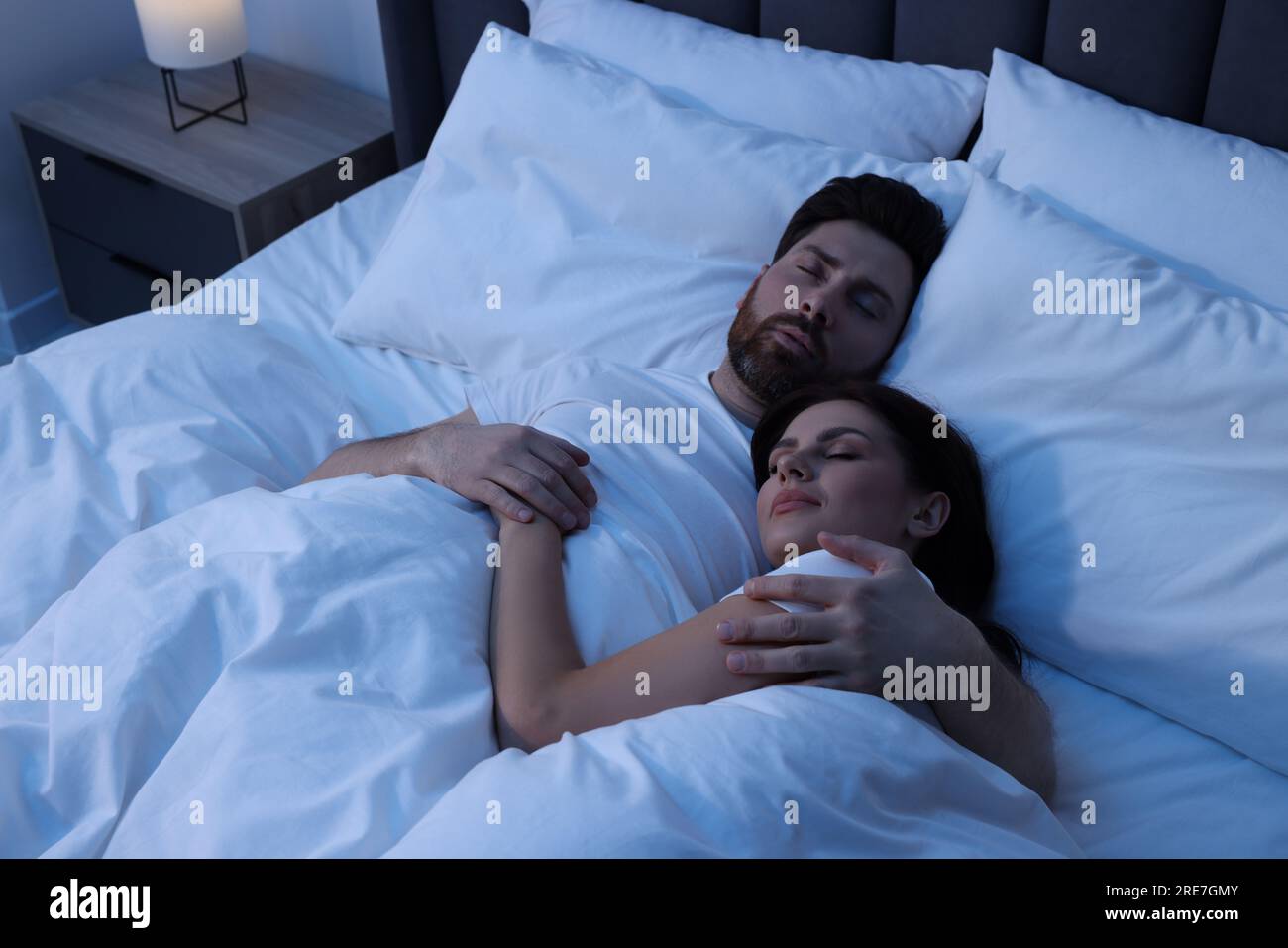 Lovely couple sleeping together in bed at night Stock Photo - Alamy