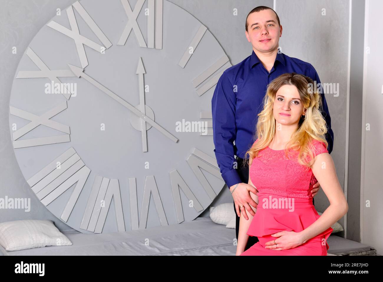 Attractive young couple is celebrating holiday at home. Standing on the ...