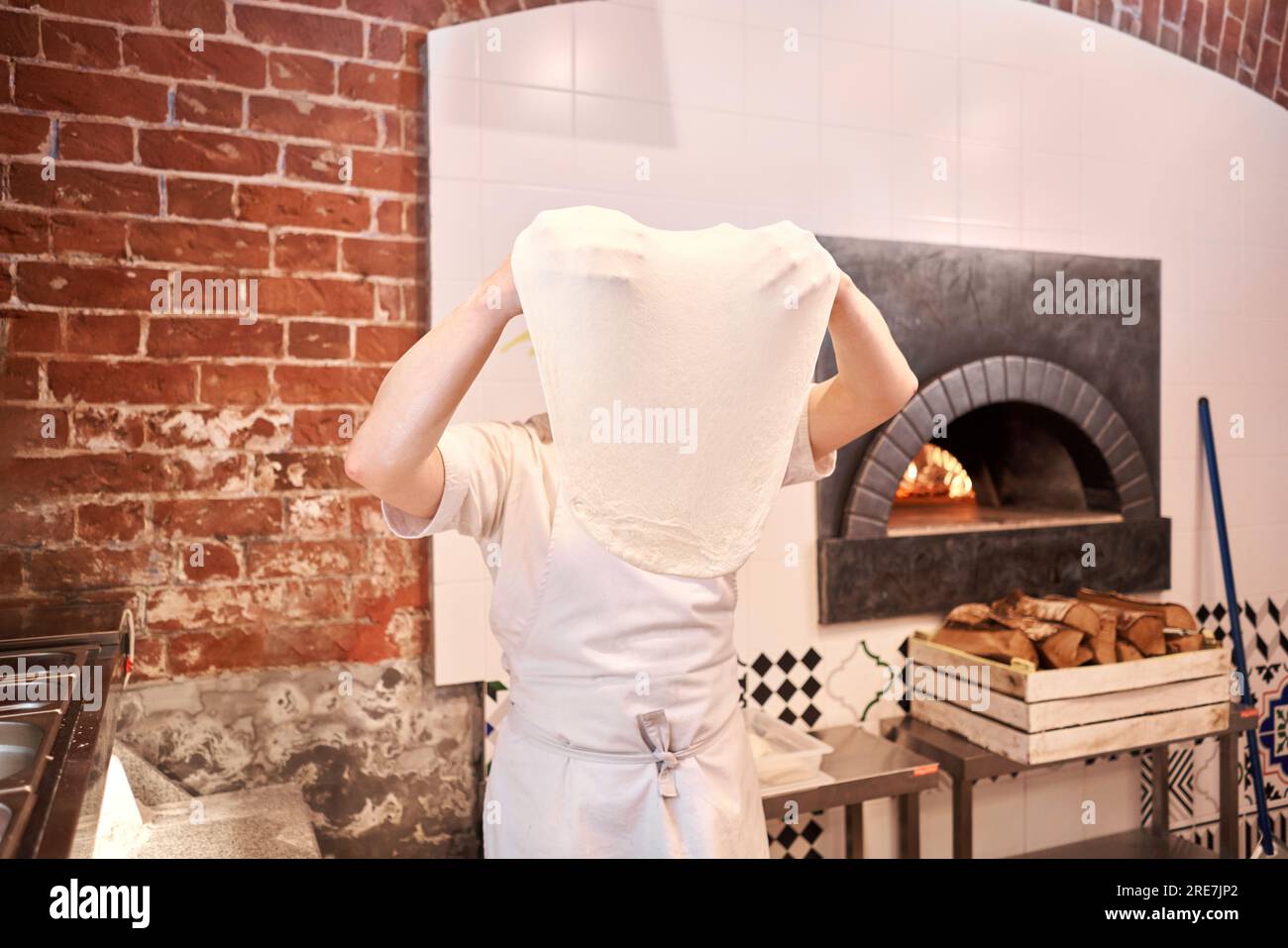 The chef prepare pizza. Raw pizza ready to bake. Cook in a apron in the ...