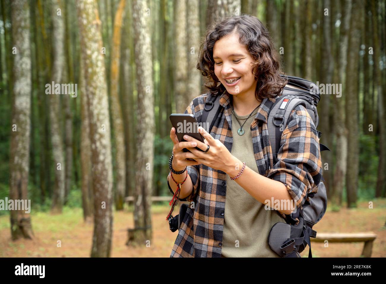Asian woman trekking while using mobile phone in the forest. Traveling ...