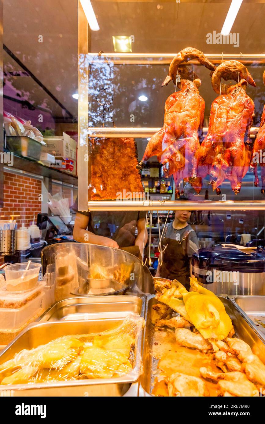 People working in a Chinese restaurant with food in the window during ...