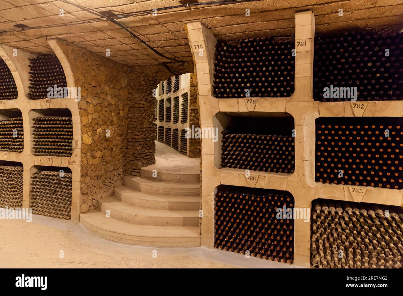 Old wine cellar with stacks of old wine bottles.Old wine bottles are ...