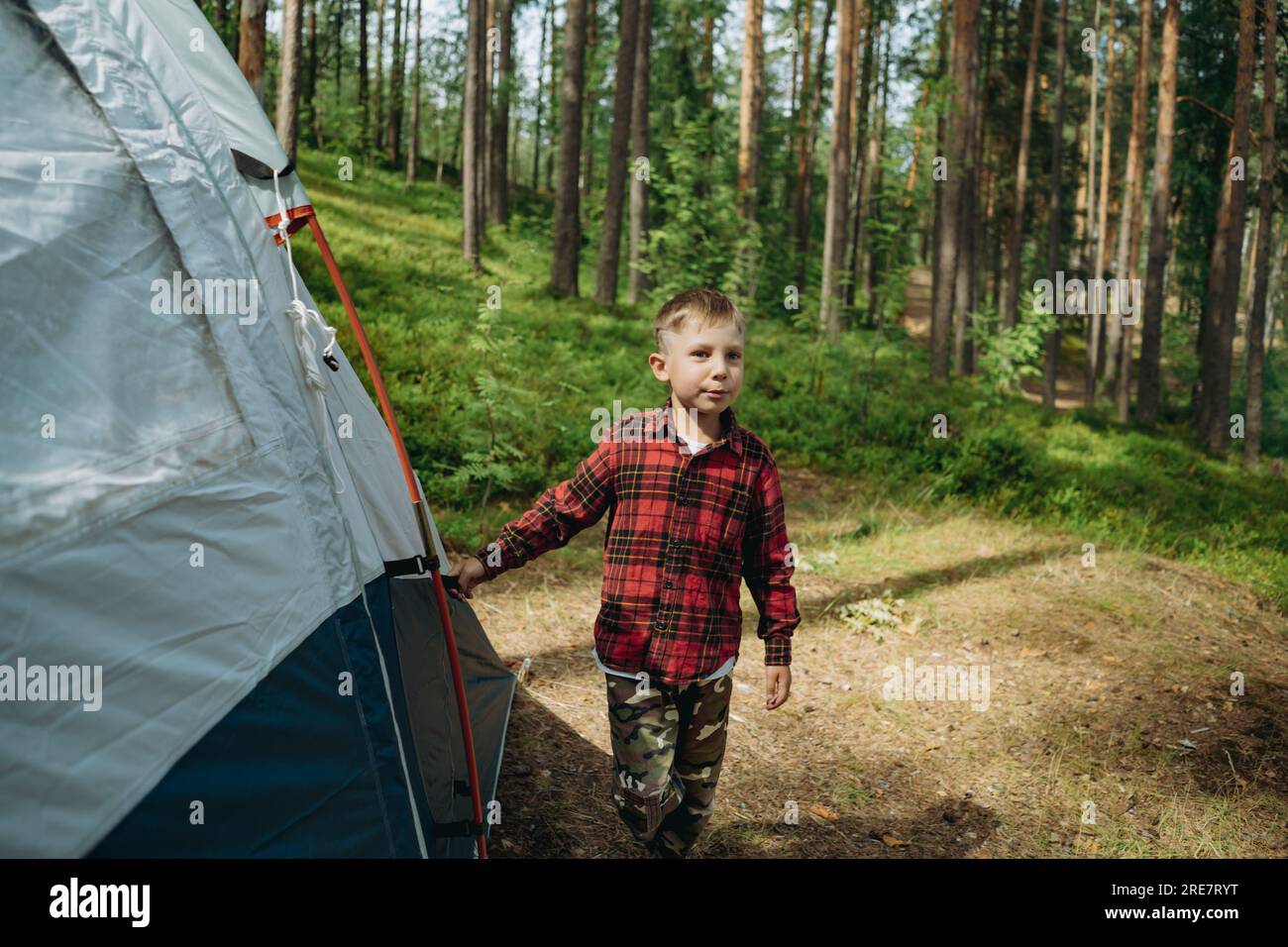 cute little caucasian boy putting up a tent. Family camping concept Stock Photo - Alamy