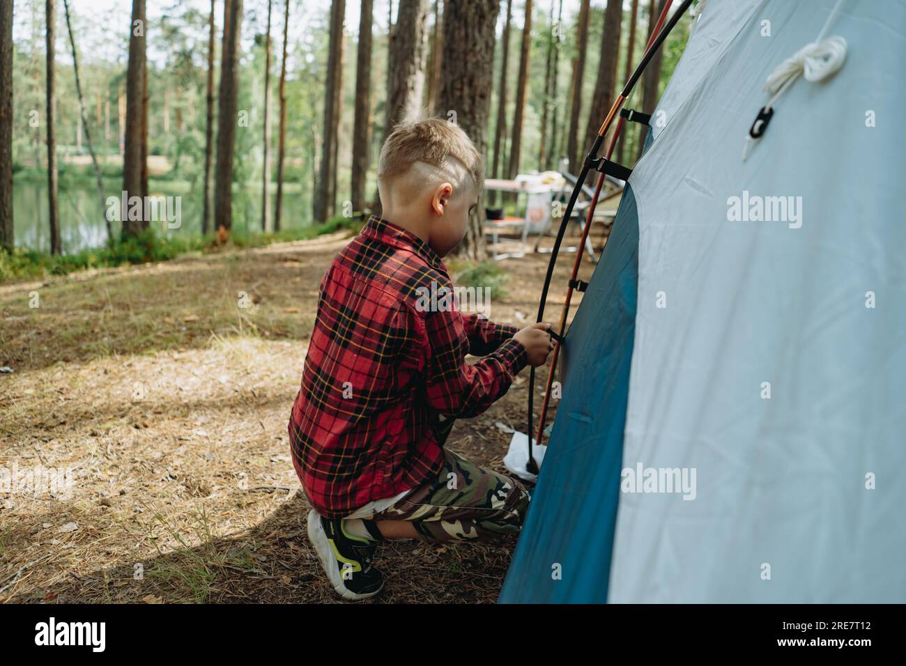 cute little caucasian boy putting up a tent. Family camping concept Stock Photo - Alamy