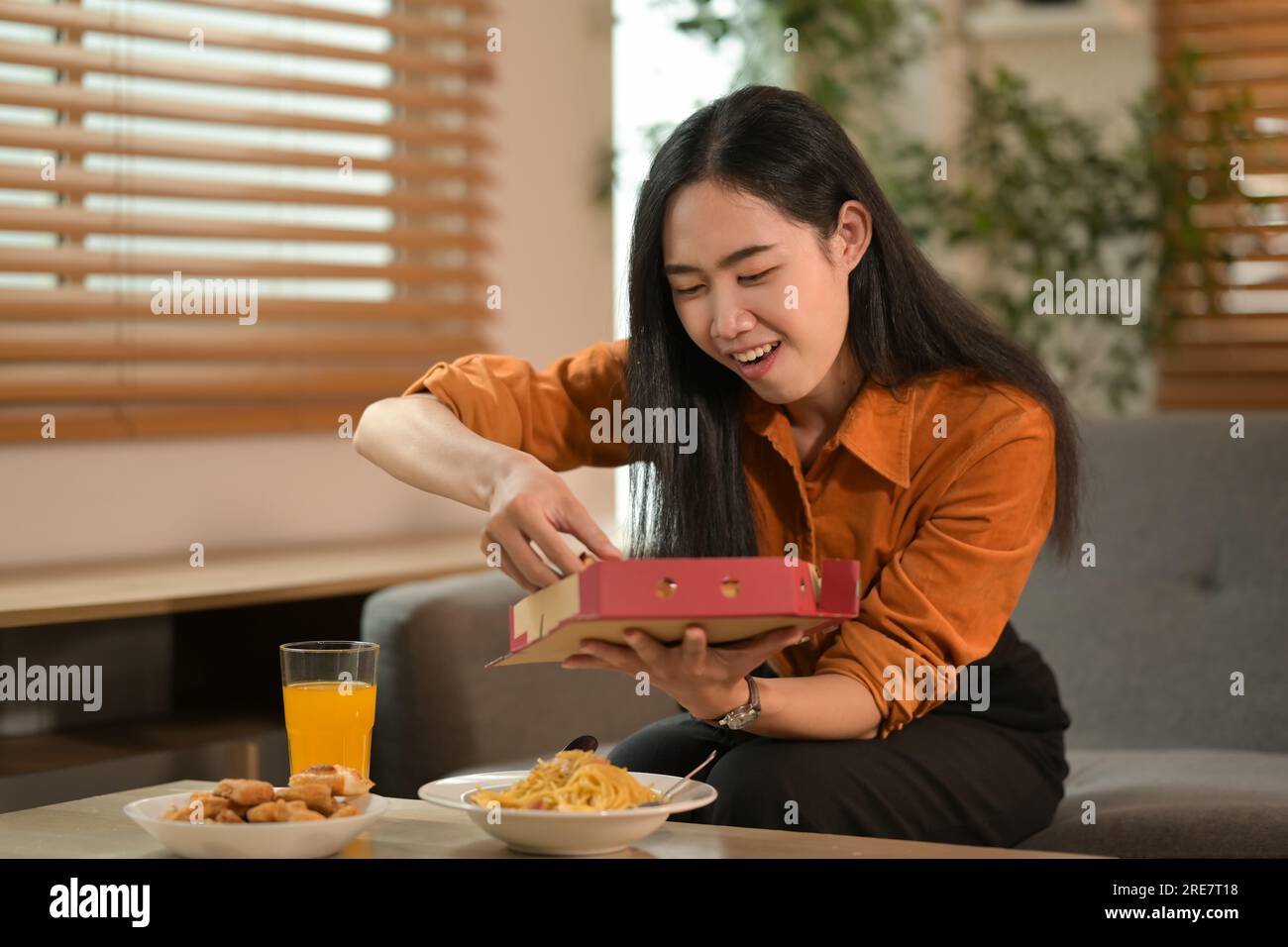 Happy woman enjoying in weekend eating pizza for lunch in cozy living ...