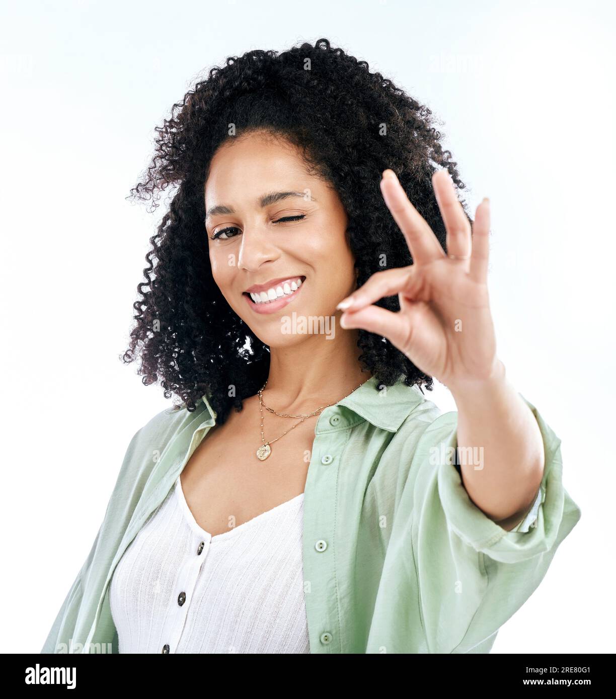 Wink, studio and woman portrait with perfect hand sign for support or ...