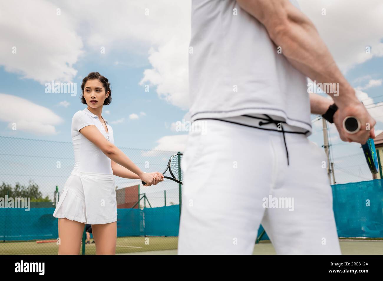 attractive woman holding tennis racquet near boyfriend on blurred ...
