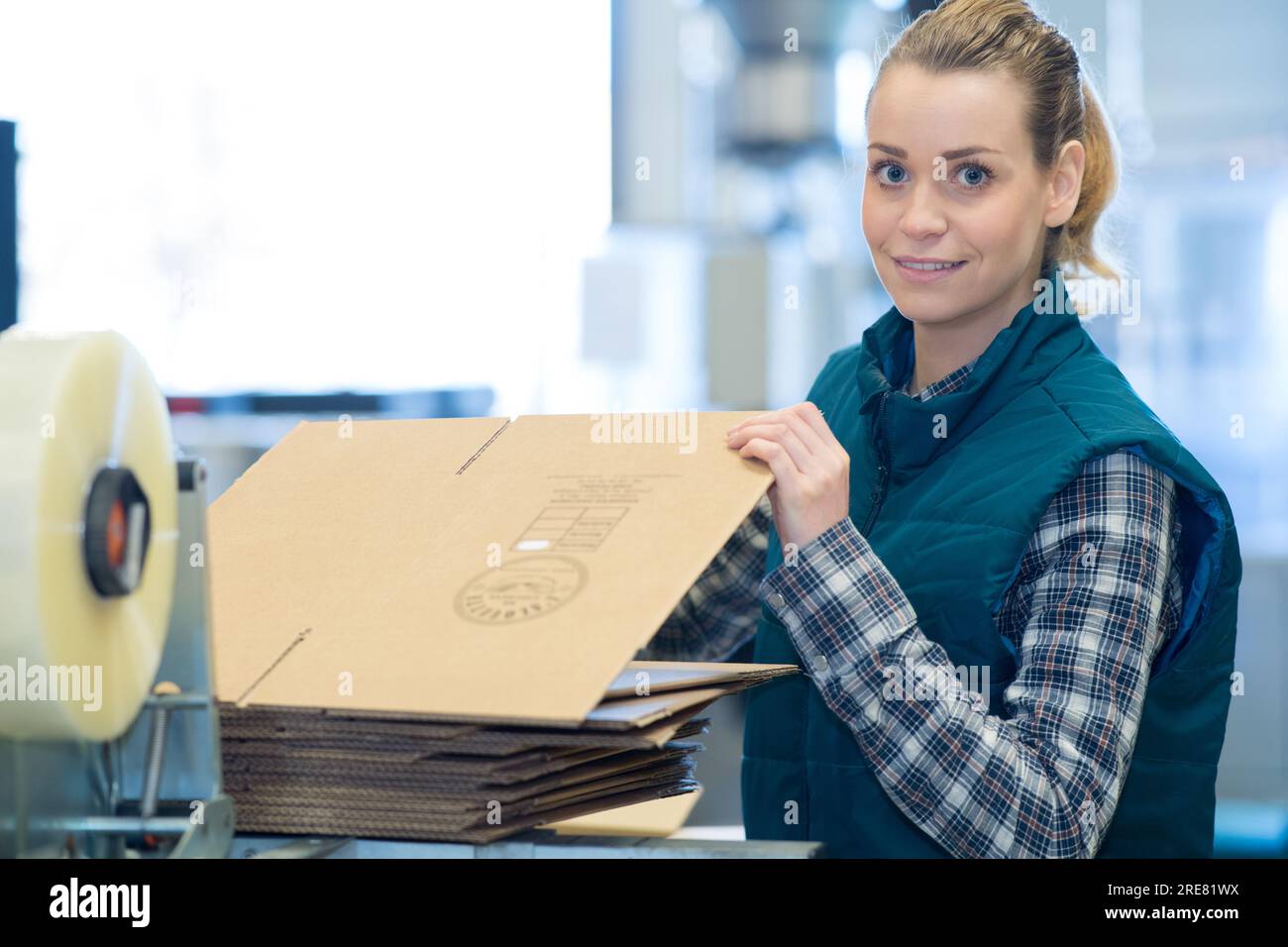 woman with stack of flatpacked boxes in factory Stock Photo - Alamy