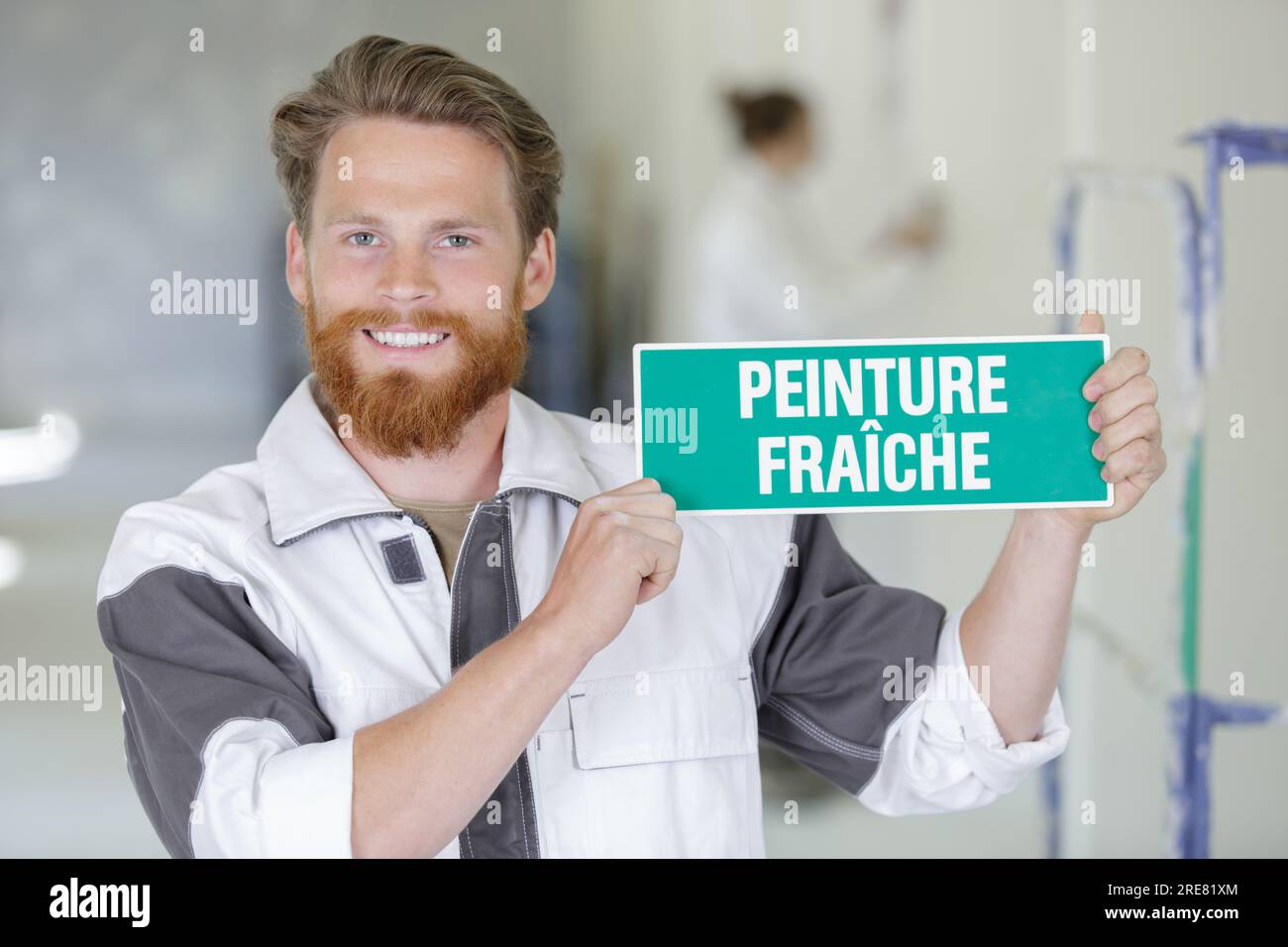 tradesman holding a wet paint sign Stock Photo - Alamy