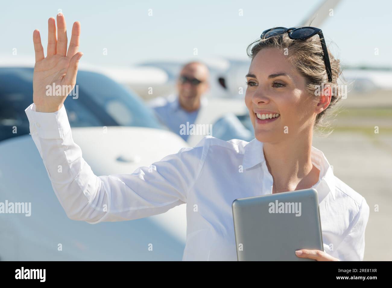 woman waving outside private aircraft Stock Photo - Alamy