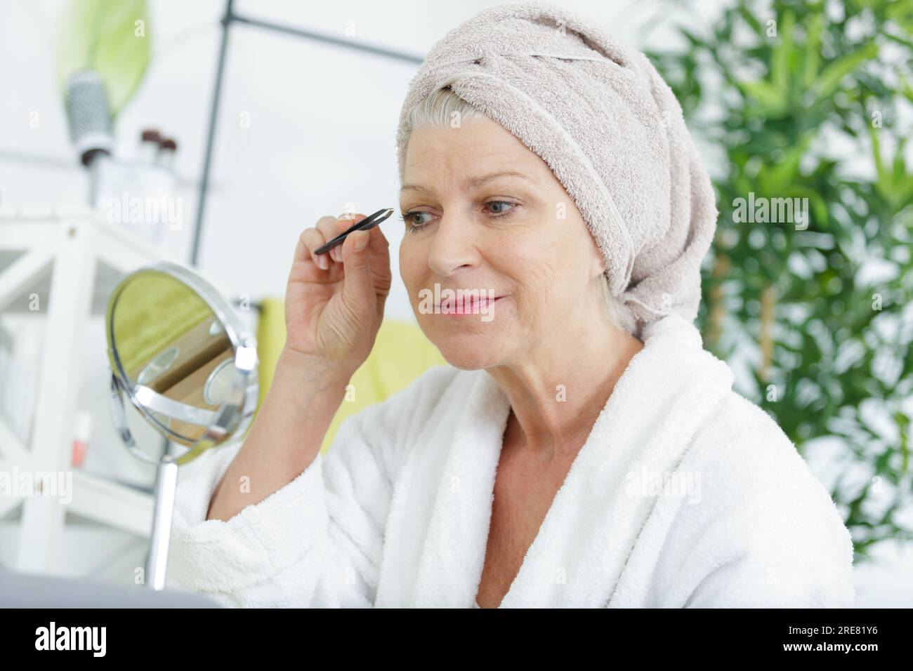 a young woman plucking eyebrows Stock Photo - Alamy