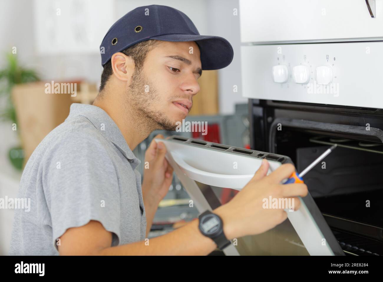 expert panel fixing the kitchen oven in a new apartment Stock Photo - Alamy
