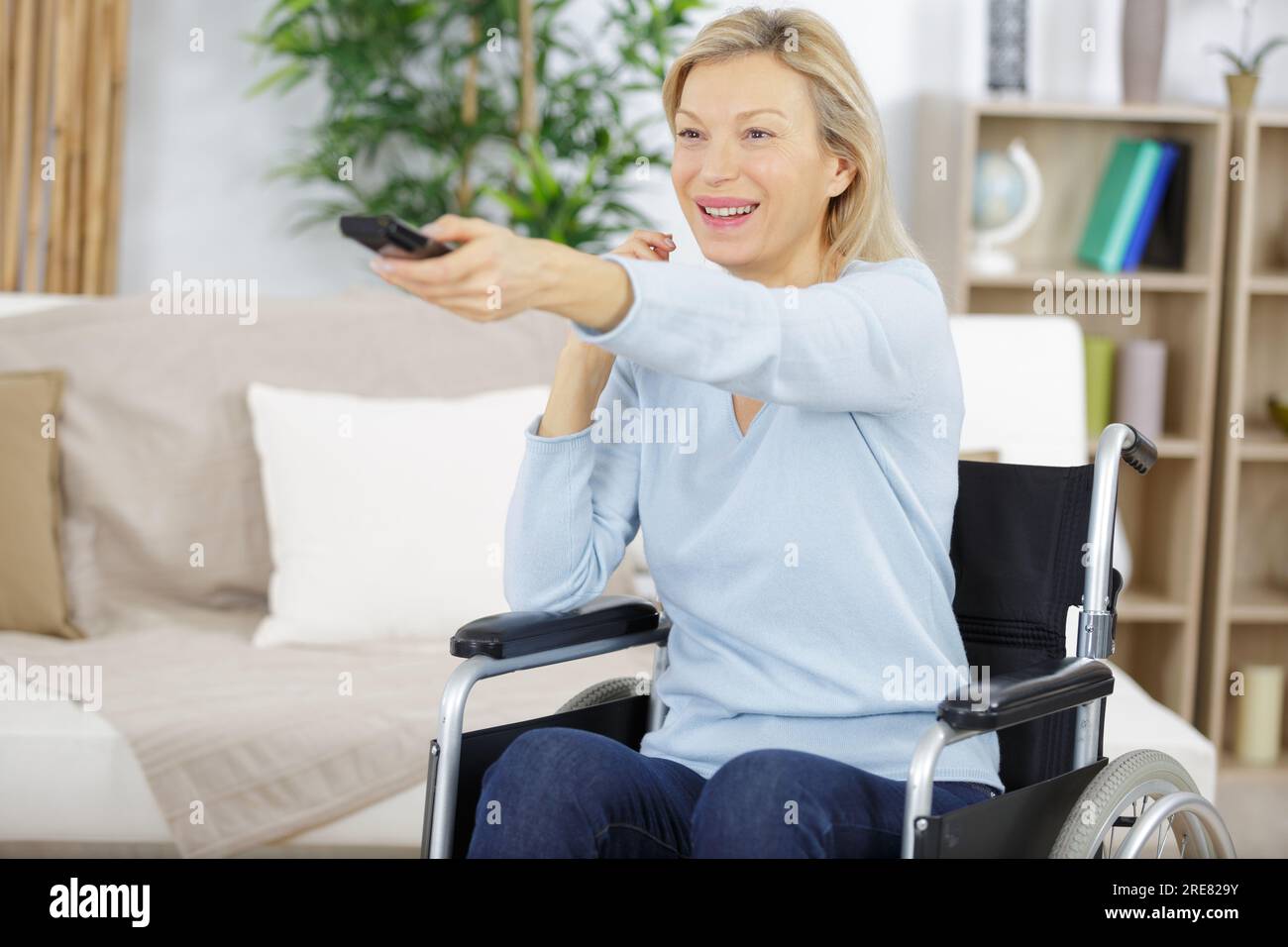 a happy senior woman in wheelchair watching tv Stock Photo - Alamy