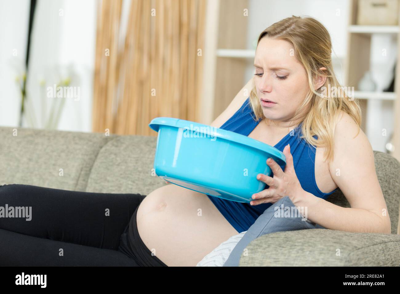 nauseous pregnant woman leaning over a bowl Stock Photo - Alamy