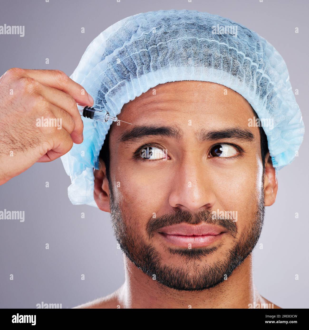 Hand, face and needle with a man in studio on a gray background for ...