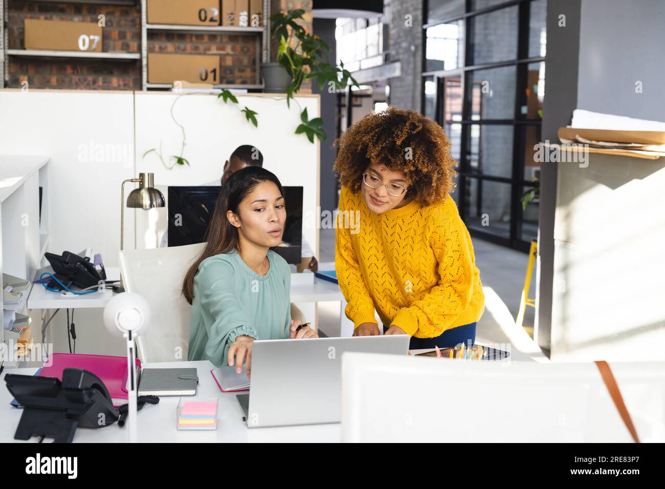 Focused diverse female colleagues with laptop discussing work in office ... Focused diverse female colleagues with laptop discussing work in office ...