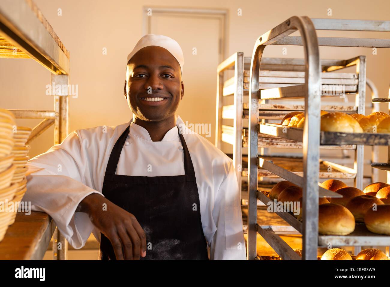 Portrait of happy african american male baker in bakery kitchen with ...