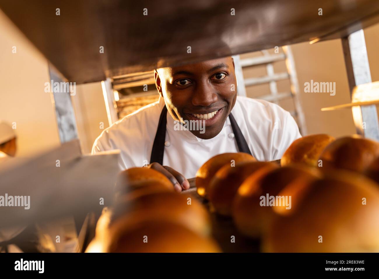 Portrait of happy african american male baker in bakery kitchen with ...