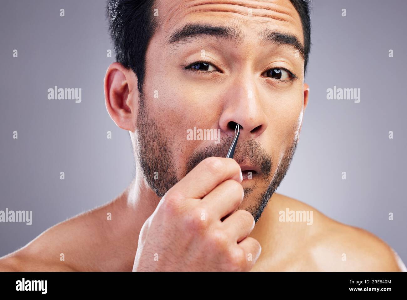 Tweezer, nose hair and portrait of man in studio for beauty, hygiene or ...