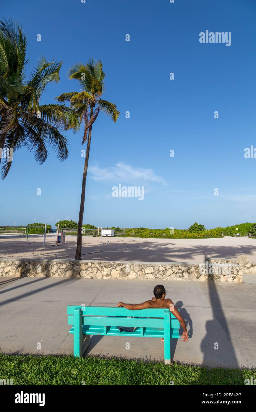 man sits at the turquoise art nouveau bench at ocean drive and enjoys ...