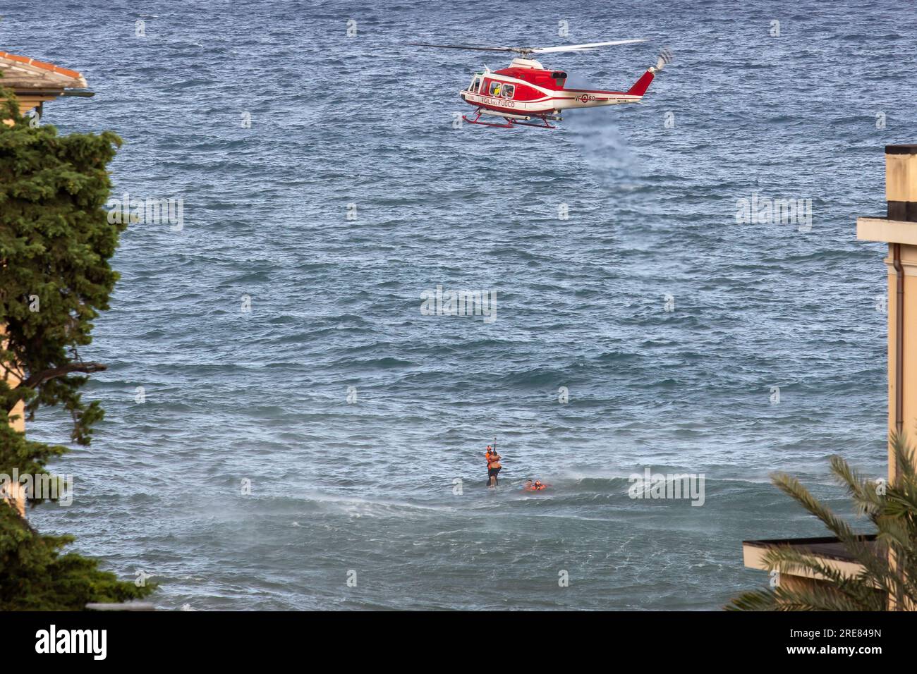 Helicopter rescue swimmers of Vigili del Fuoco assist a group of ...