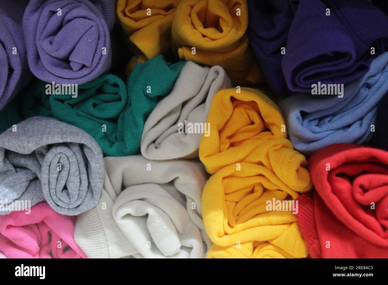 A close up photo of colourful beach towel rolled up and put on display ...