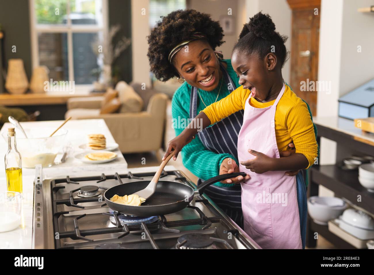 Happy african american mother and daughter baking pancakes in kitchen at home Stock Photo - Alamy