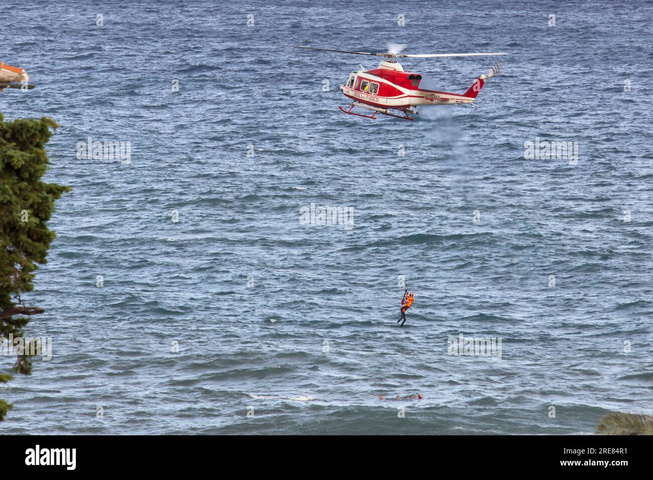 Helicopter rescue swimmers of Vigili del Fuoco assist a group of ...