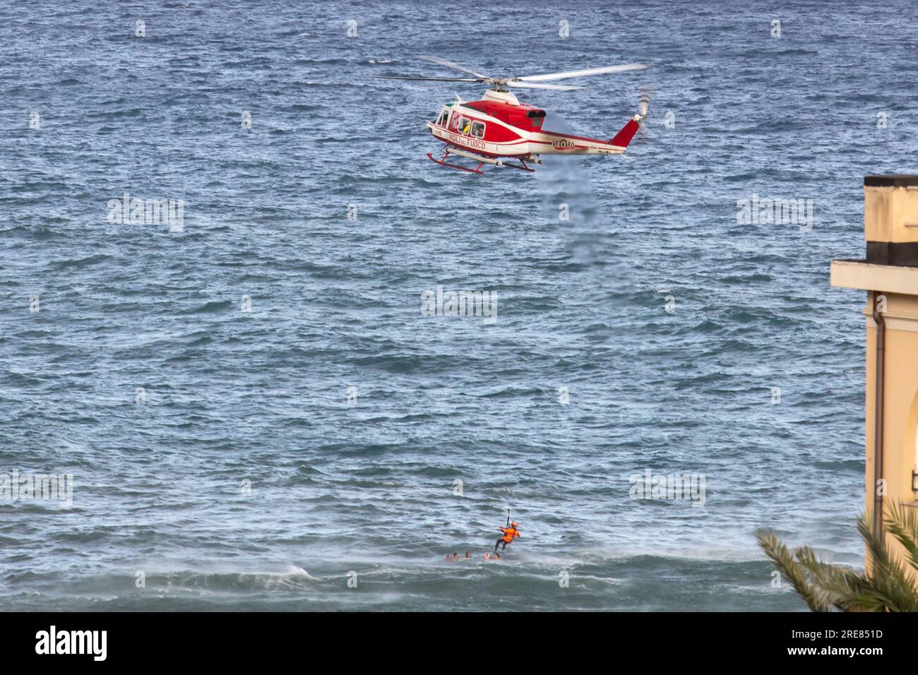 Helicopter rescue swimmers of Vigili del Fuoco assist a group of ...