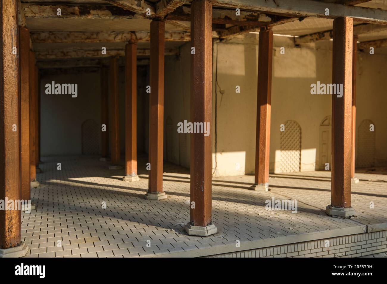 A view of an old mosque with a porch, portico of slender wood columns ...