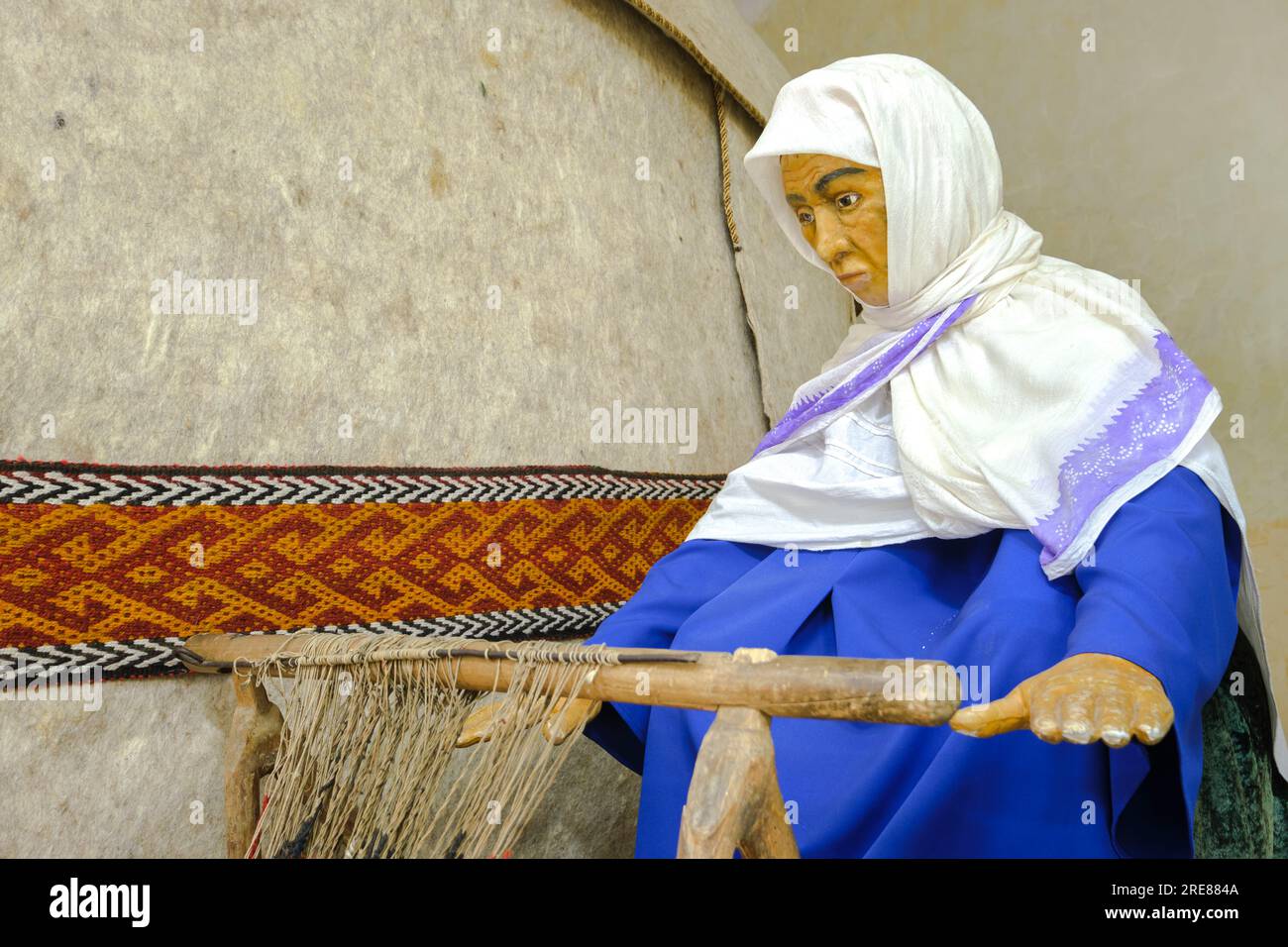 A diorama of an old woman weaving a textile, cloth. At the South ...
