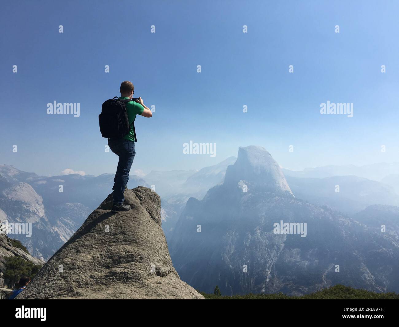 Rear View of a man photographing Half Dome from Glacier Point, Yosemite ...