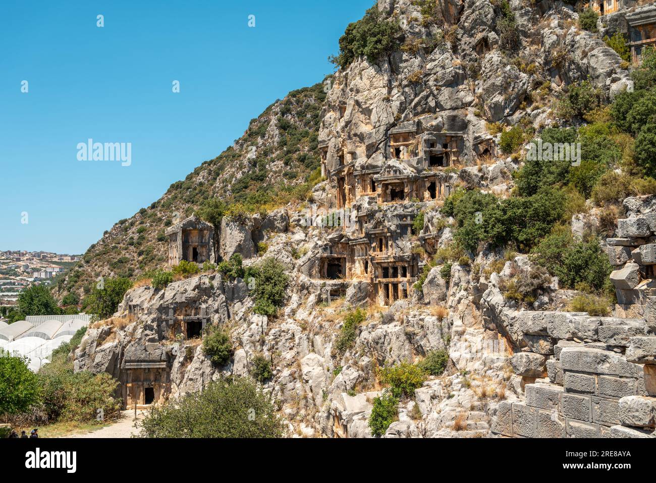 The ruins of the amphitheater and ancient rock tombs in the ancient city of Myra in Demre ...