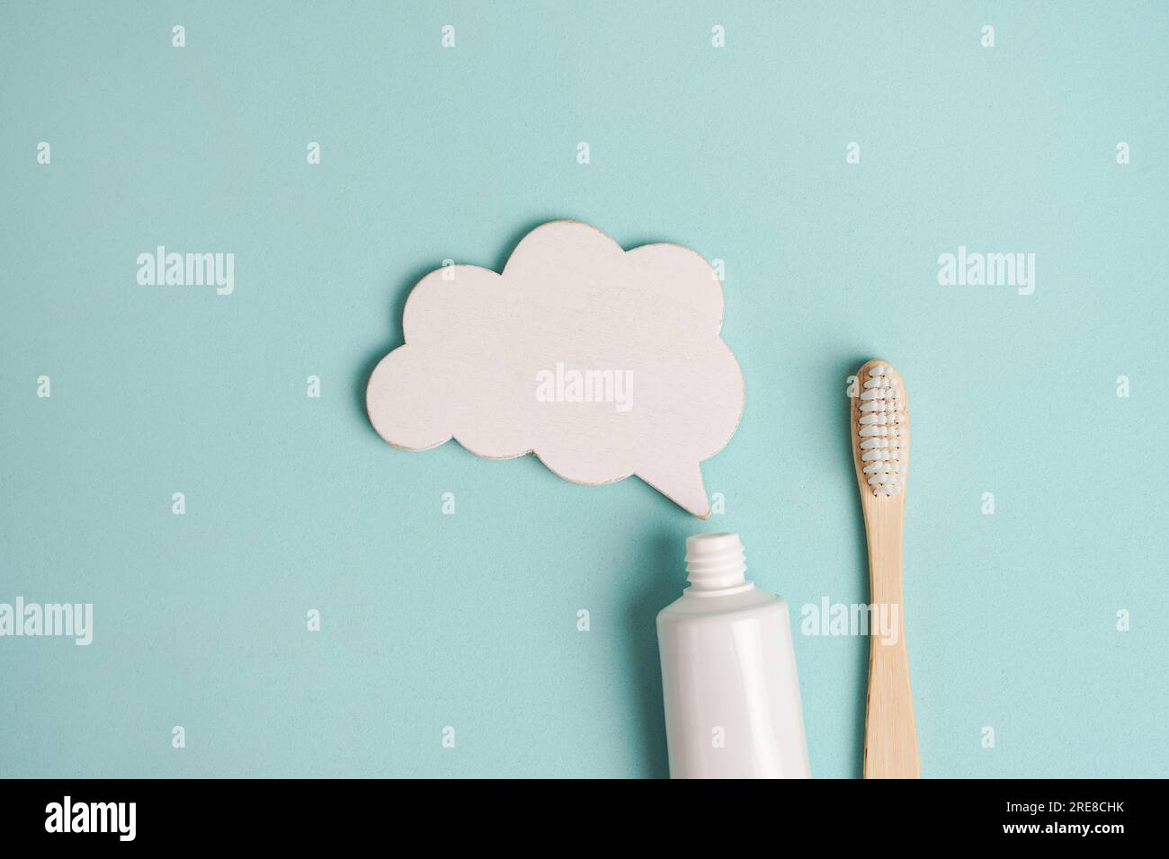 Blank white tube of toothpaste with white cloud and wood brush on blue ...
