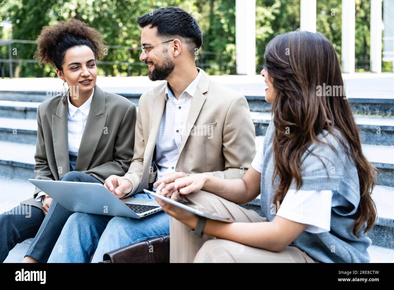 Group of business people in front of an office building gossiping with ...