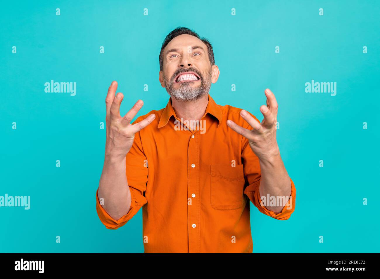 Portrait of crazy mad furious man with gray beard dressed orange shirt ...
