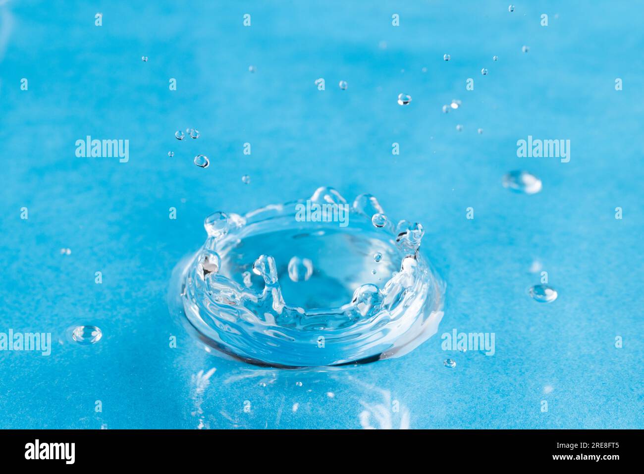 Close up of water drop falling into water with ripples and copy space ...