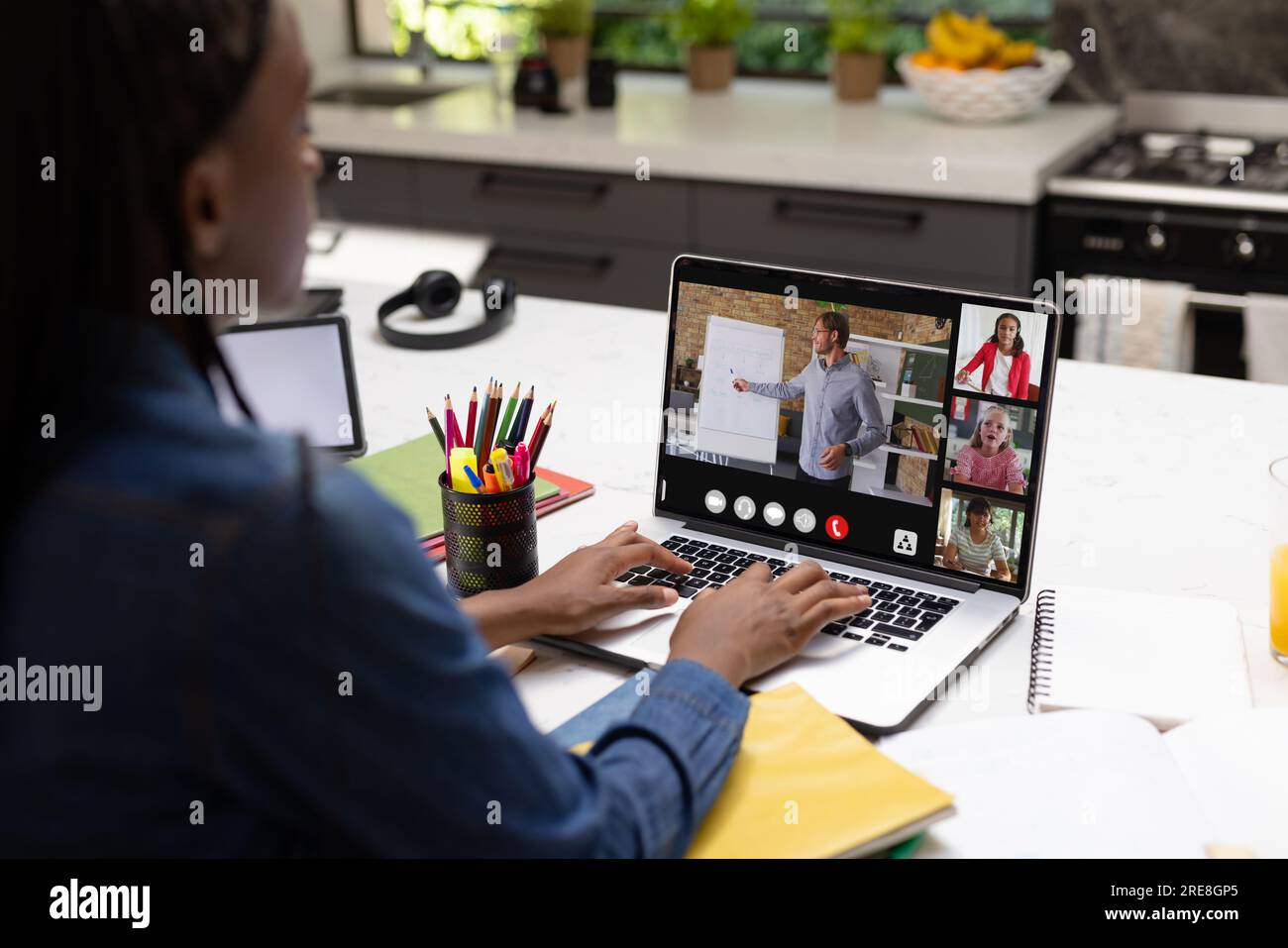 African american schoolgirl having a video call with male teacher and ...