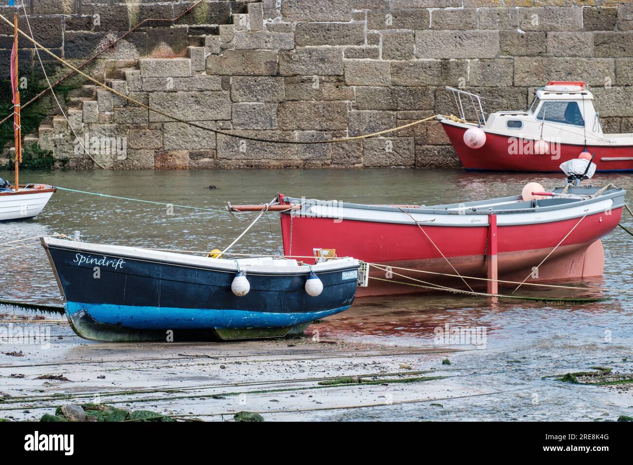 Closeup of small boats berthed at Mousehole harbour during low tide ...
