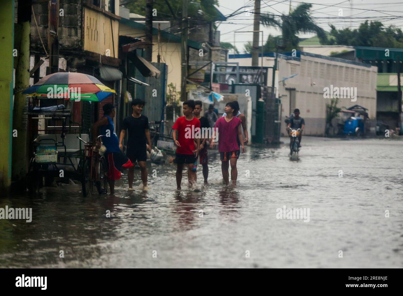 Malabon City, Philippines. 26th July, 2023. People wade through a water-logged area in Malabon ...