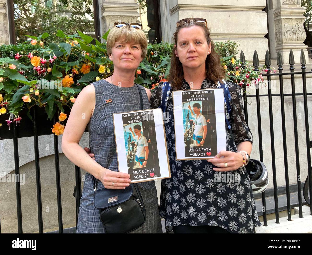 Liz Gardner (left) and Meg Parsons holding pictures of their brother ...