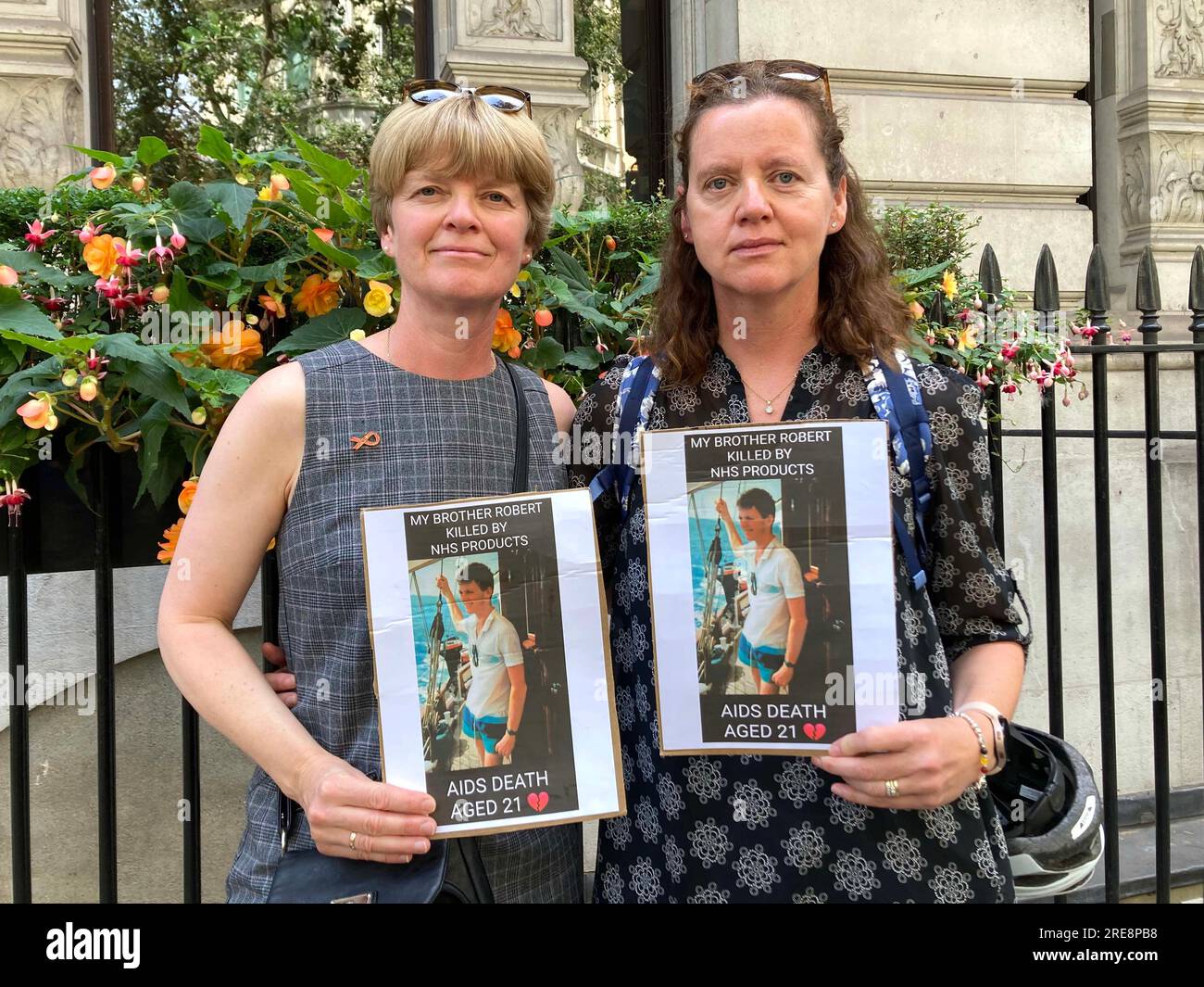 Liz Gardner (left) and Meg Parsons holding pictures of their brother Robert Gibbs outside the ...