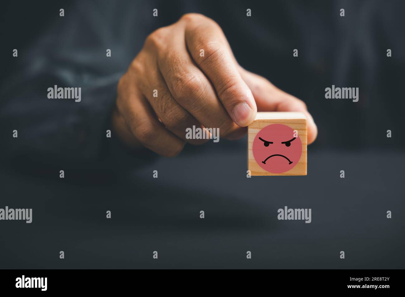 Unhappy customer hand with a sadness emotion face on a wooden block ...
